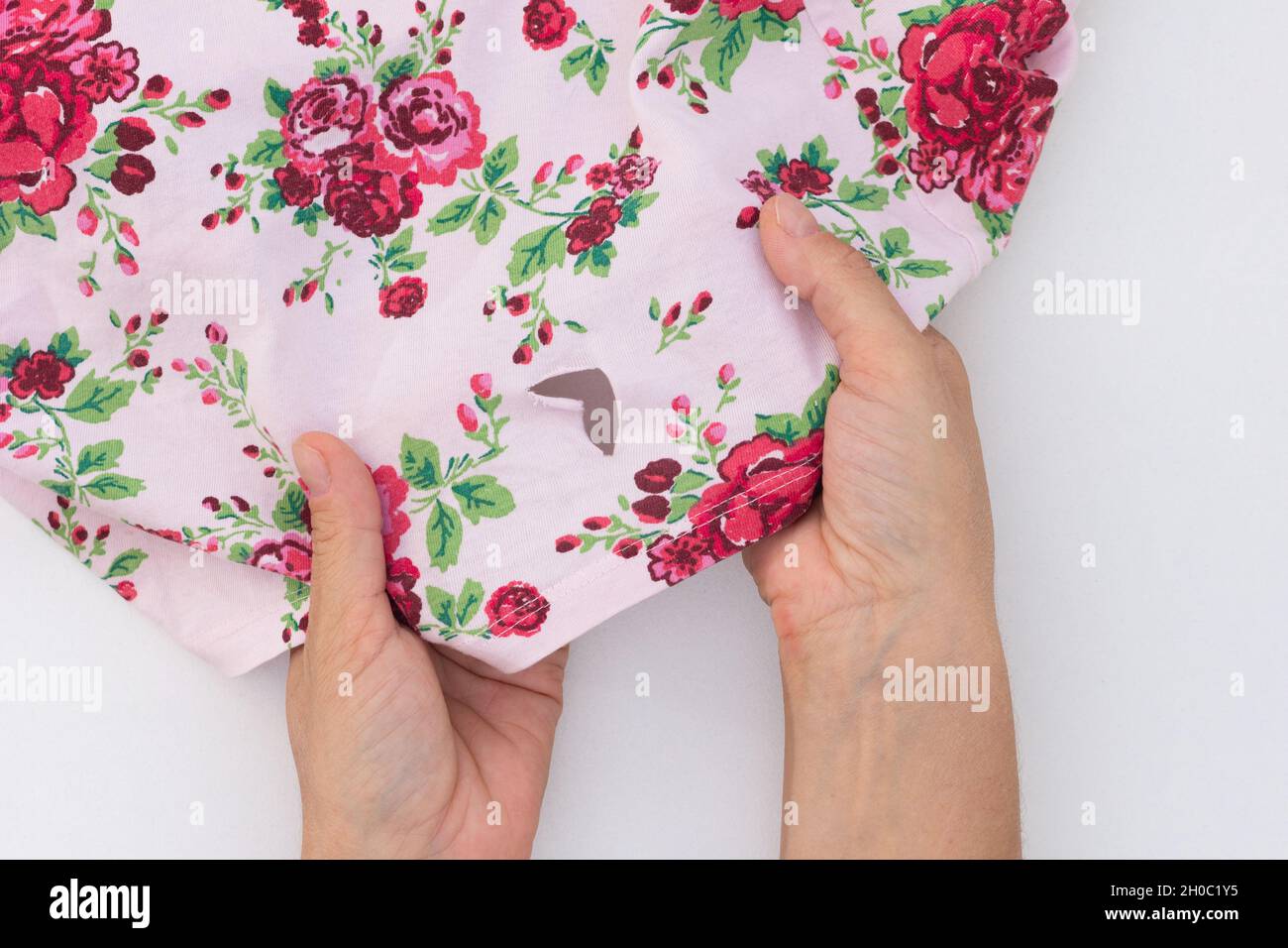 Woman hand holding torn cloth showing hole on white background Stock ...