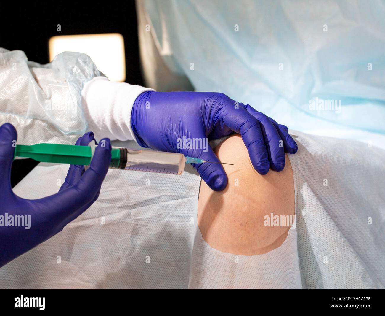 The doctor makes a therapeutic intra-articular injection into the knee ...