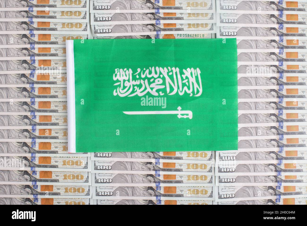 Saudi Arabia flag on a background from dollar banknotes. Concept of the ...
