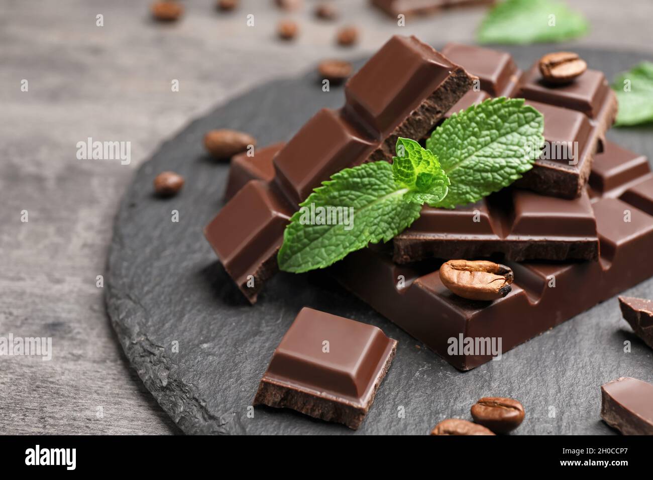 Pieces of dark chocolate with mint on slate plate Stock Photo - Alamy