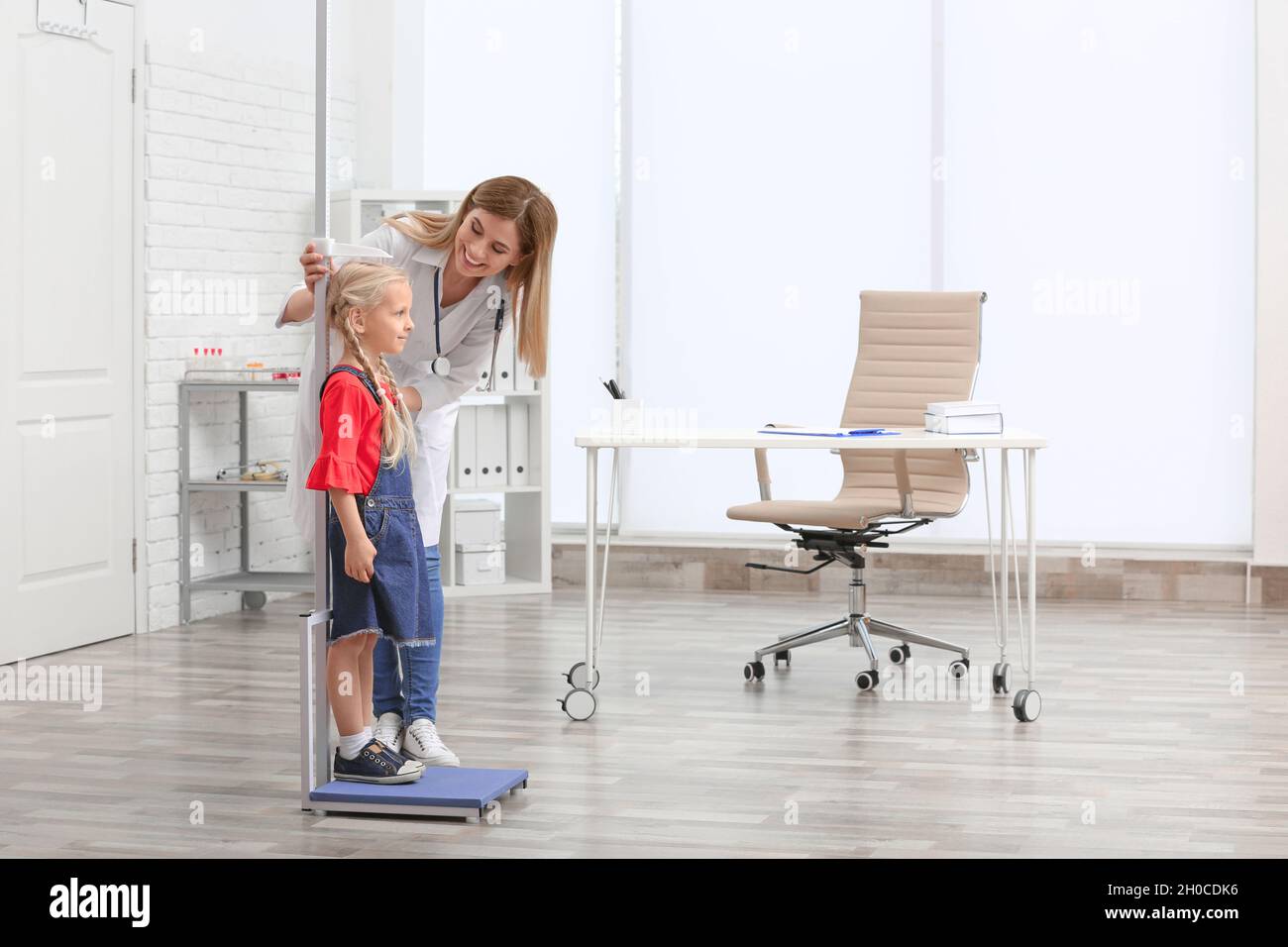 Doctor measuring little girl's height in hospital Stock Photo - Alamy