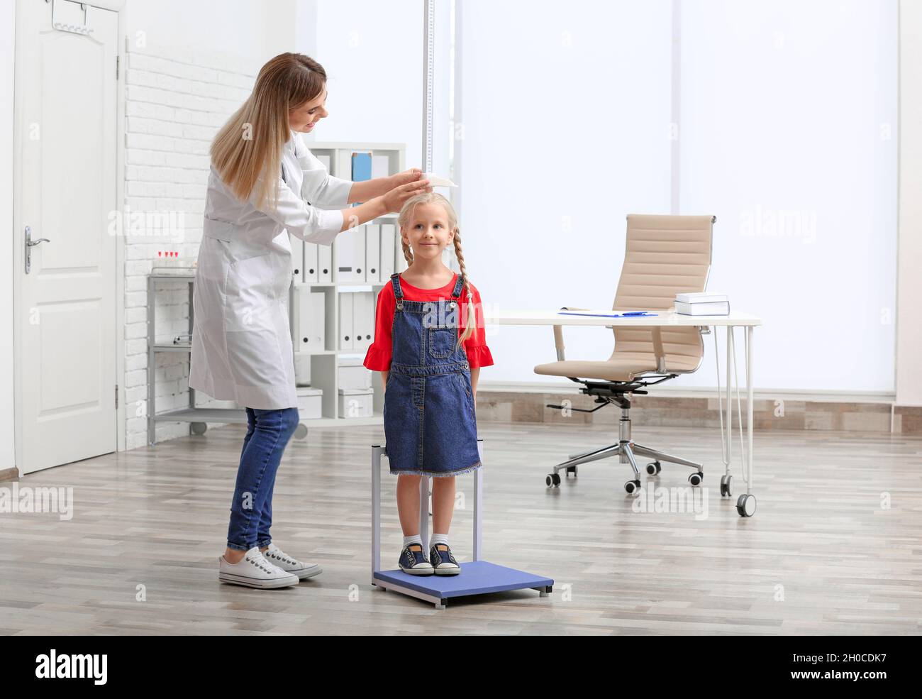 Doctor measuring little girl's height in hospital Stock Photo - Alamy