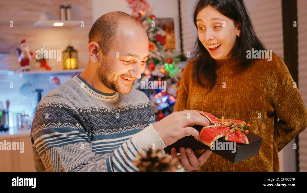 Festive woman giving present box to man celebrating christmas eve ...