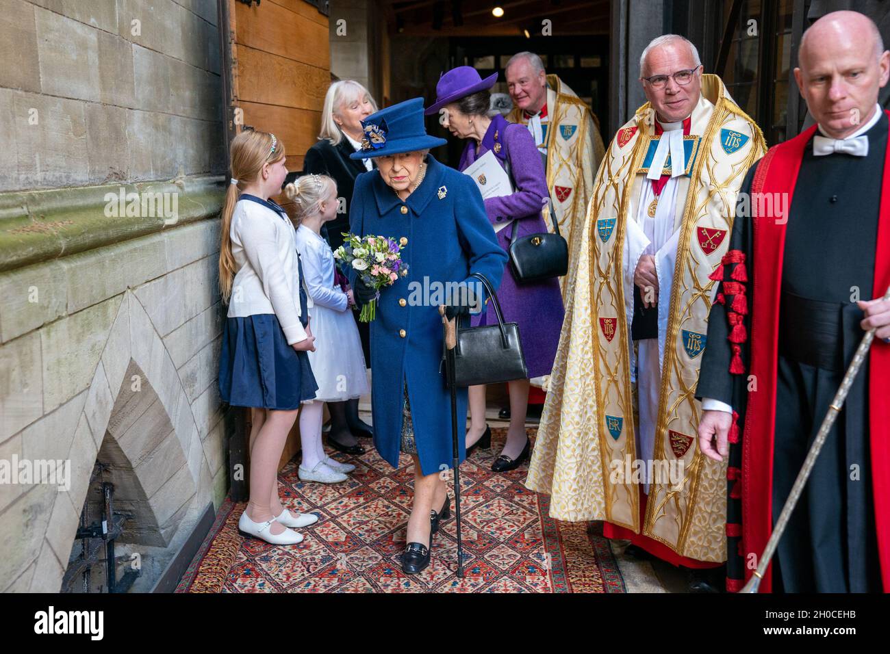 Queen Elizabeth II uses a walking stick as she arrives with the ...
