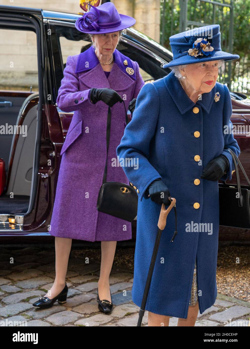 Queen Elizabeth II uses a walking stick as she arrives with the ...