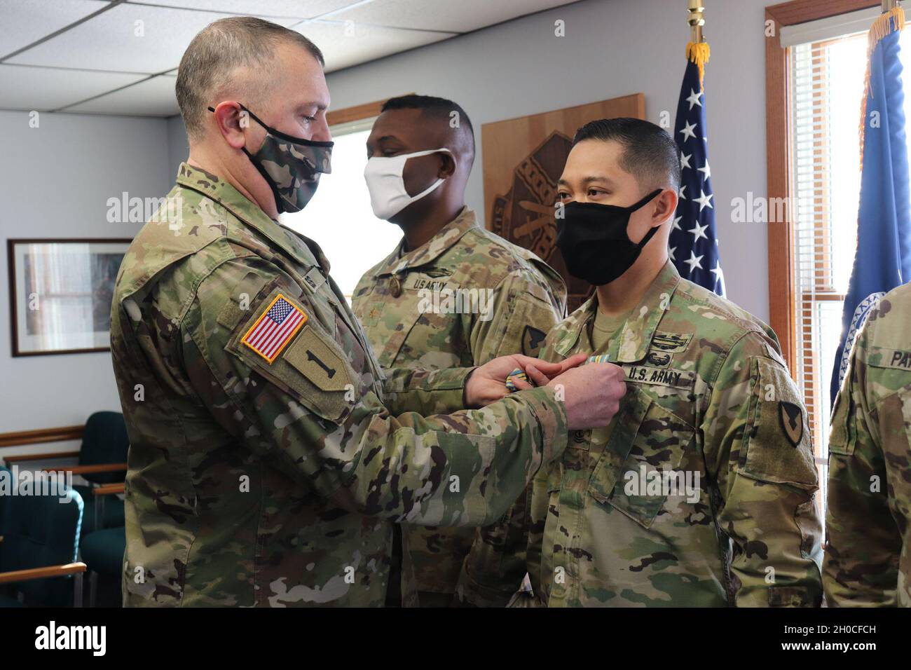 Garrison Commander Col. Michael D. Poss presents the Military Outstanding Volunteer Service ...