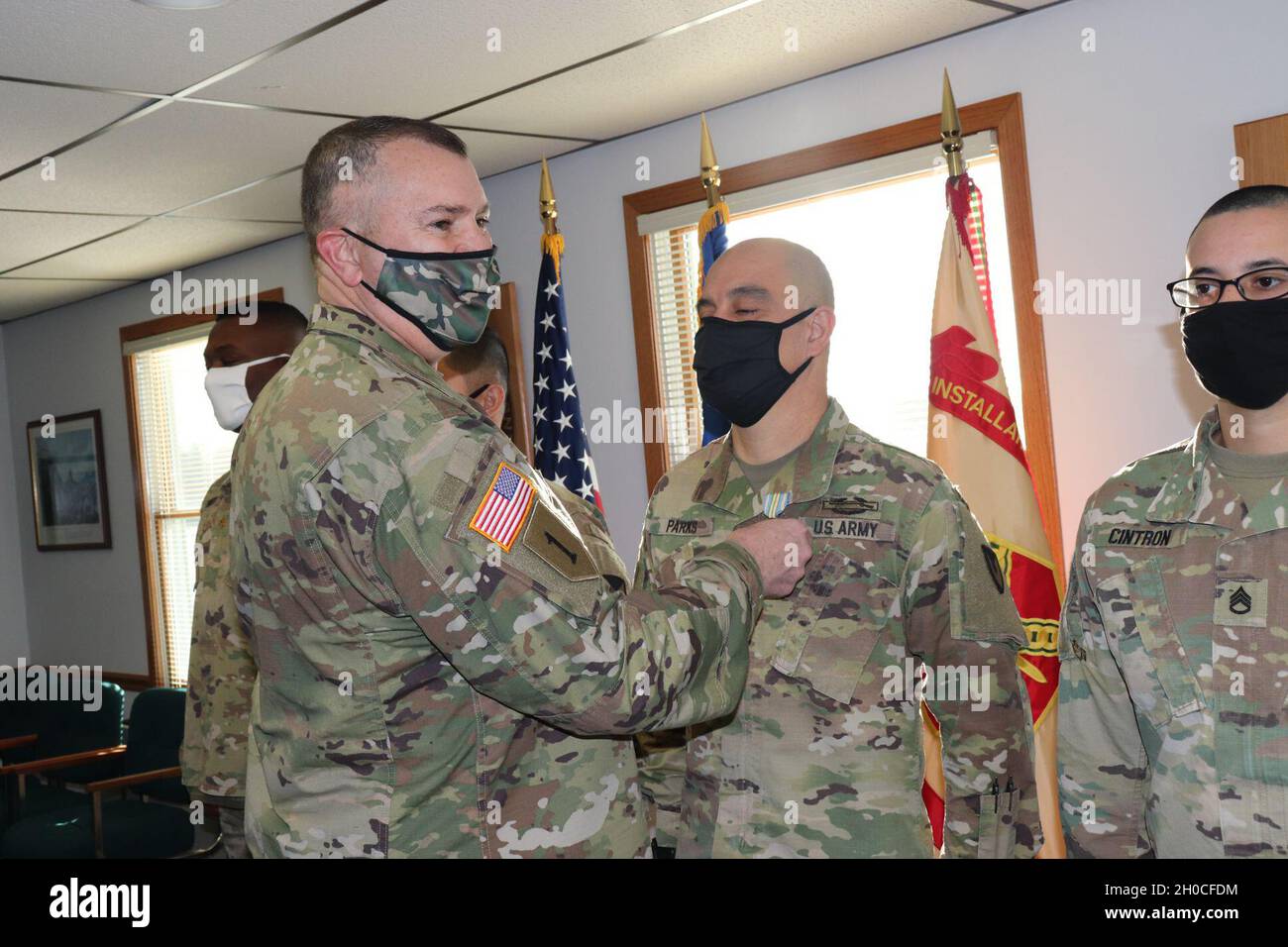 Garrison Commander Col. Michael D. Poss presents the Military Outstanding Volunteer Service ...
