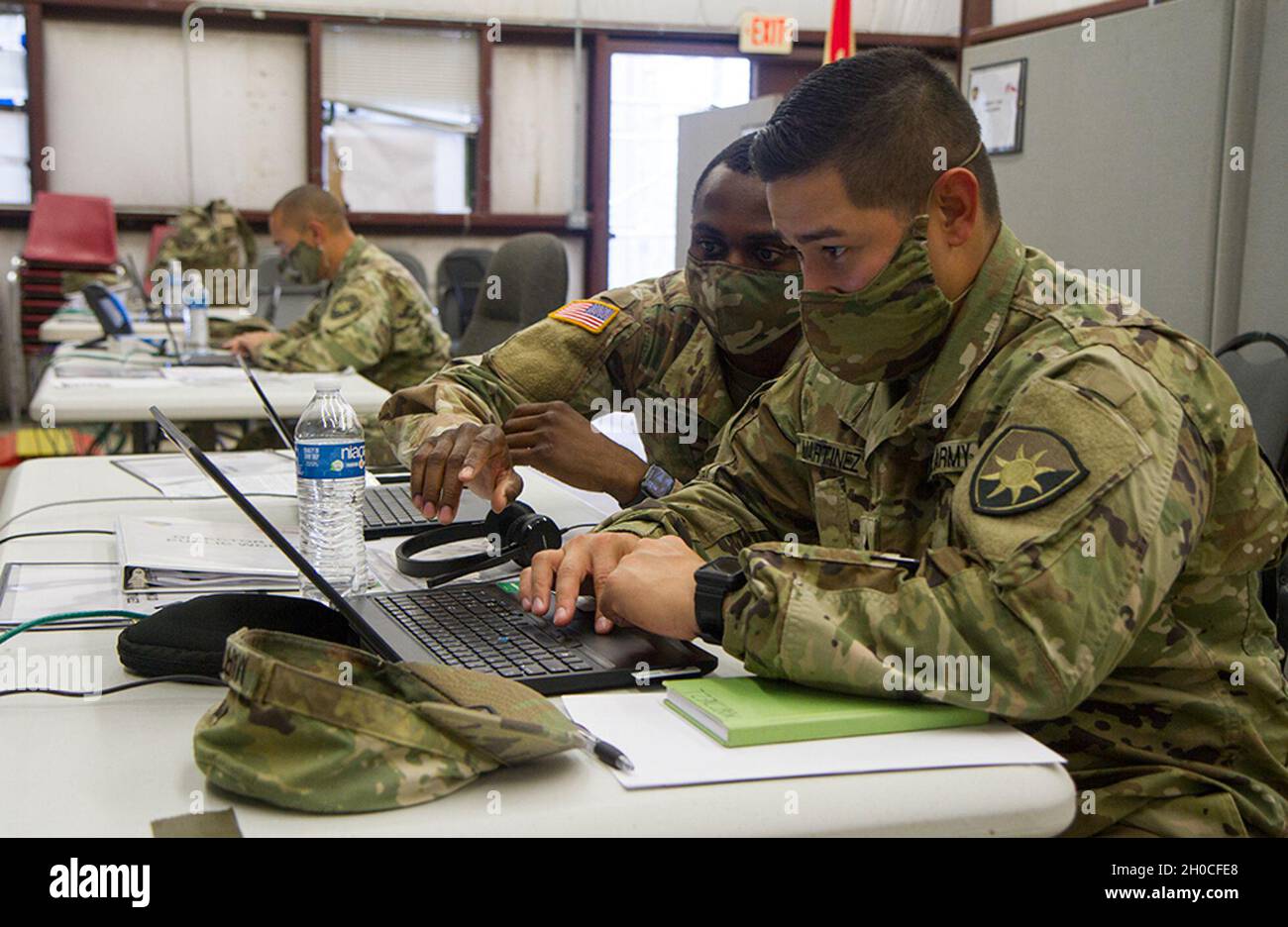 Spc. Chynard McKay points out a detail on an invoice to Army Sgt. Luis ...