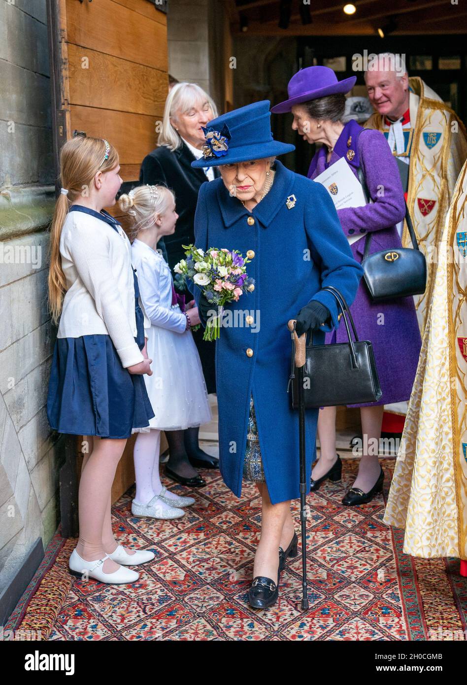 Queen Elizabeth II uses a walking stick as she arrives with the ...