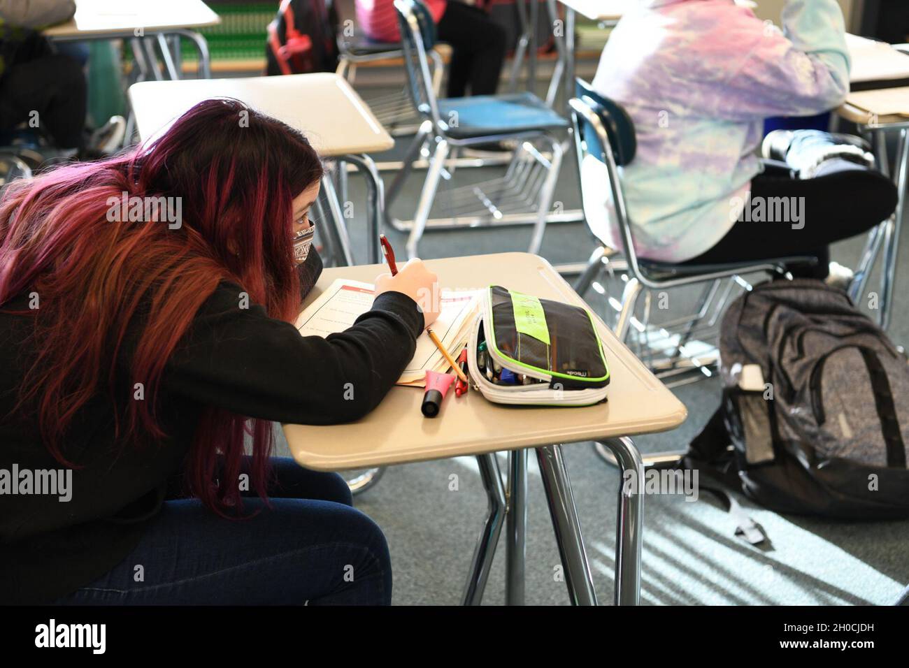 Middle school student takes notes in class at Aviano Middle High School ...