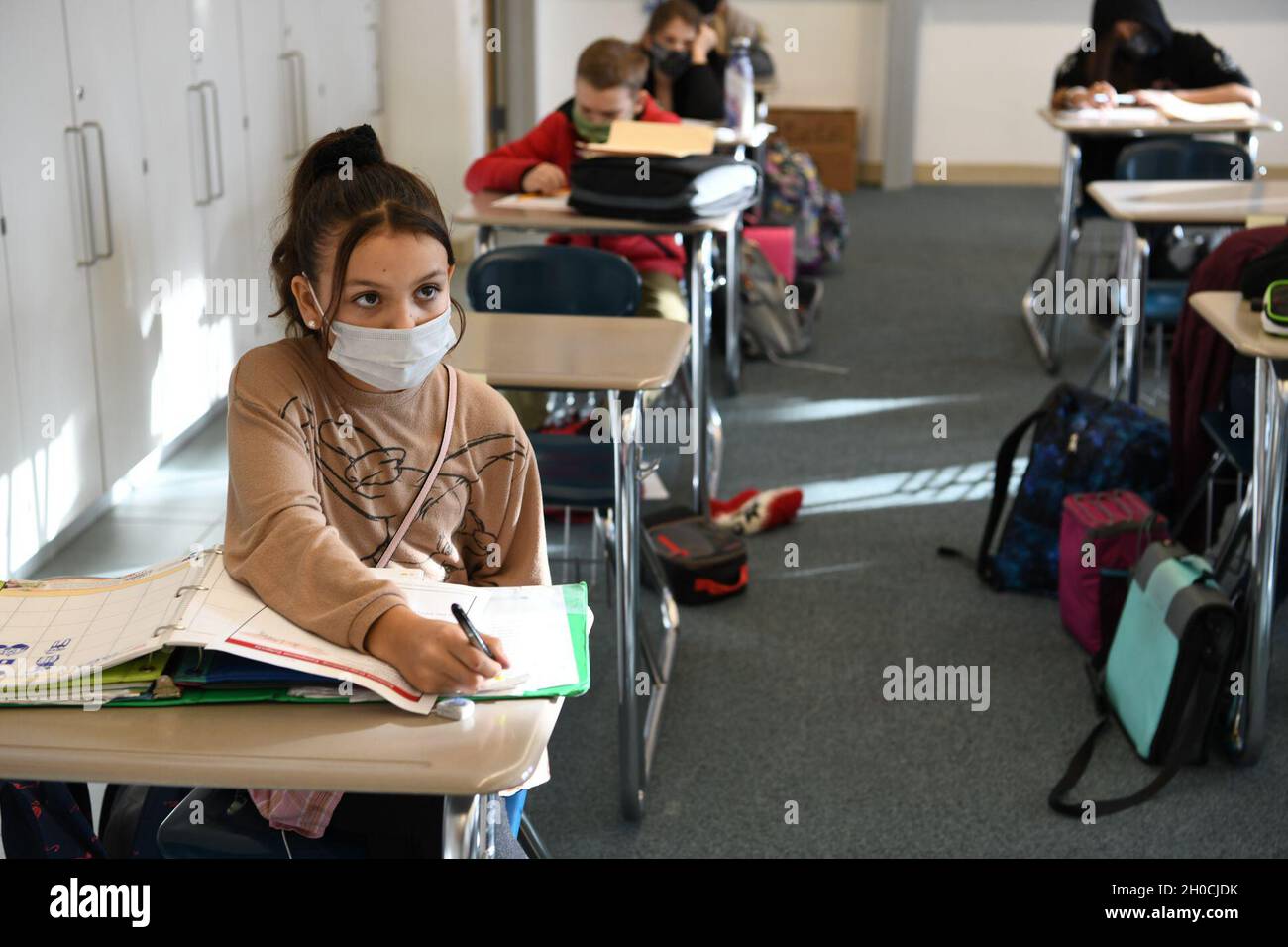 Middle school student takes notes in class at Aviano Middle High School ...