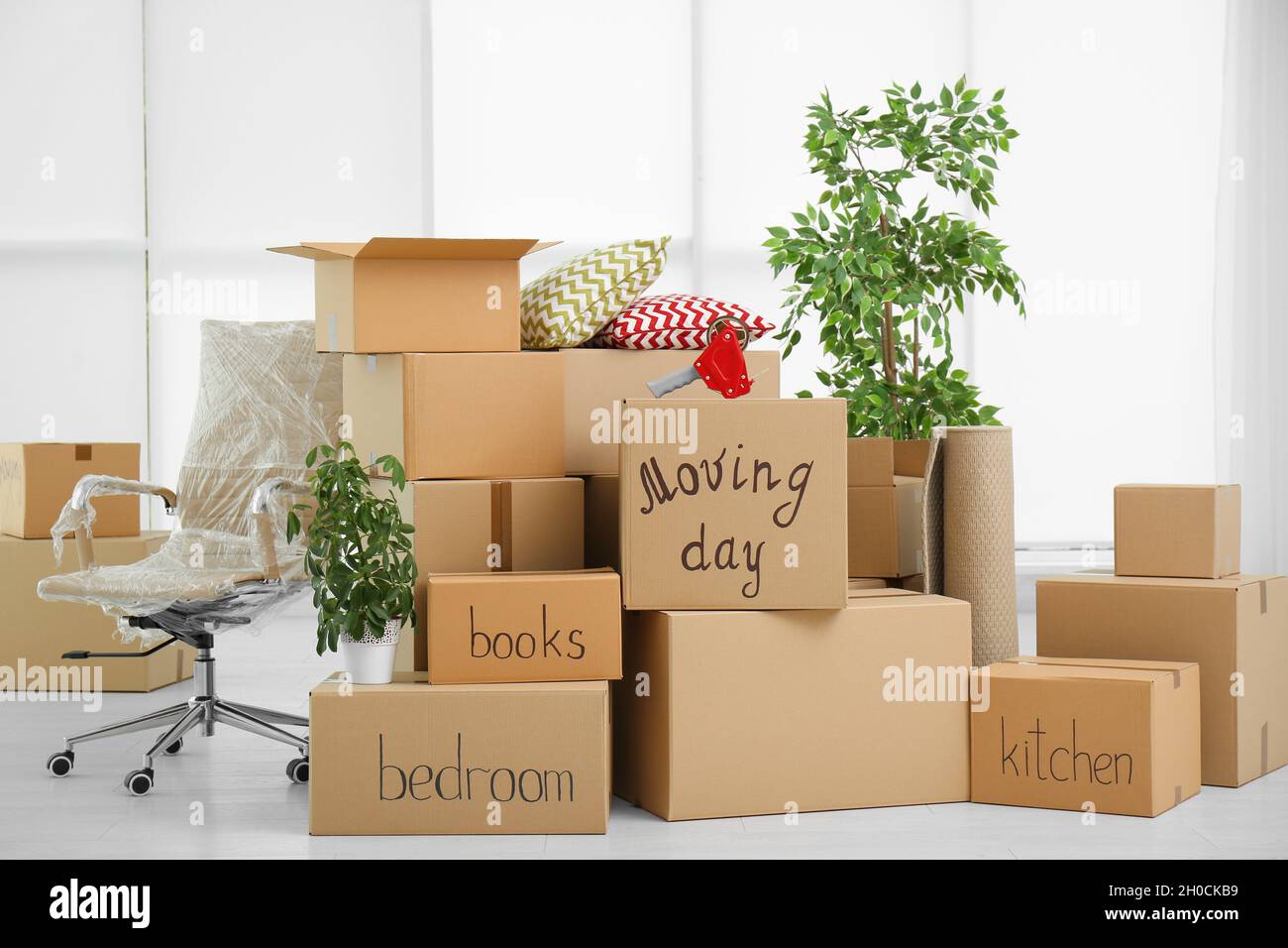 Pile of moving boxes in empty room Stock Photo - Alamy