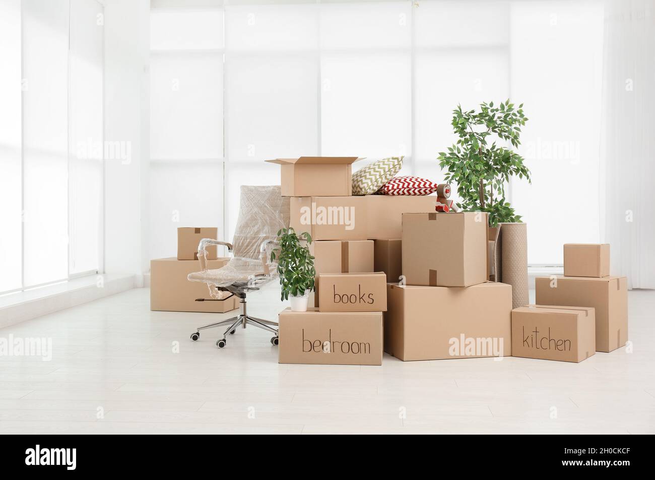 Pile of moving boxes in empty room Stock Photo - Alamy