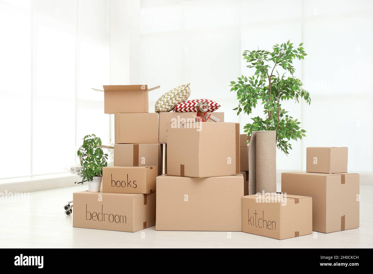 Pile of moving boxes in empty room Stock Photo - Alamy