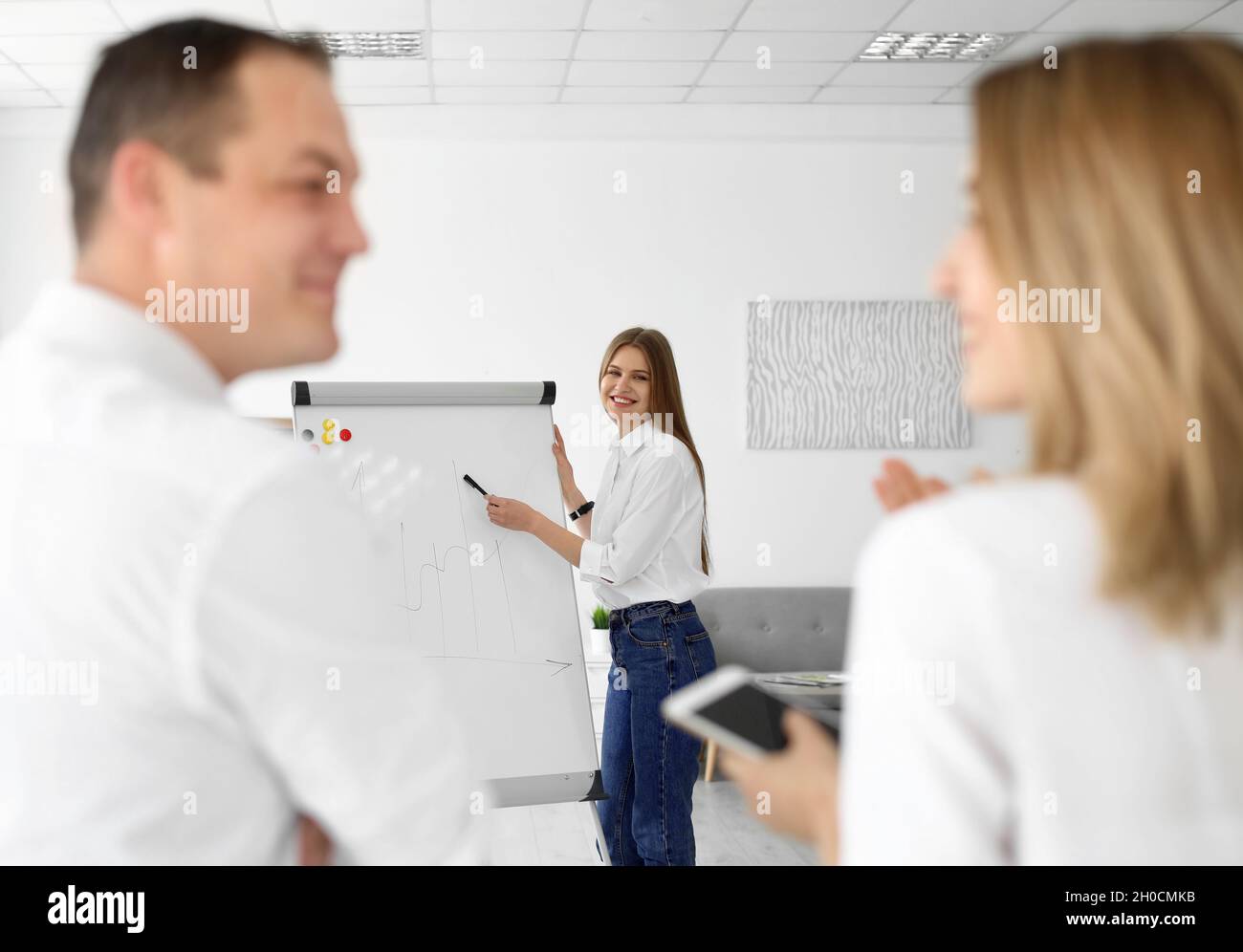 Female business trainer giving lecture in office Stock Photo - Alamy