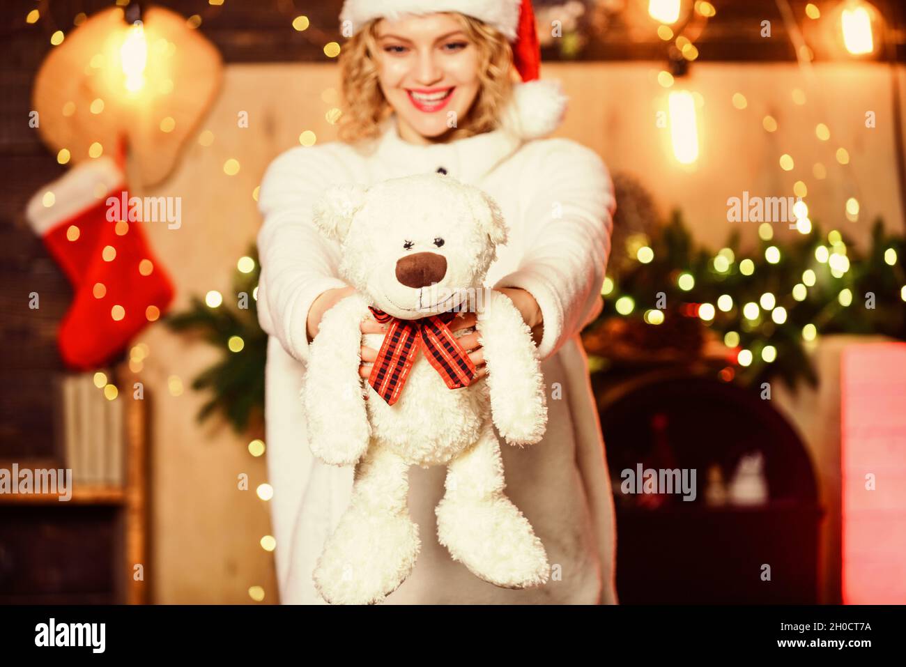 Cheerful woman blurred background. In sweater. xmas mood. Woman toy bear present. girl in red ...