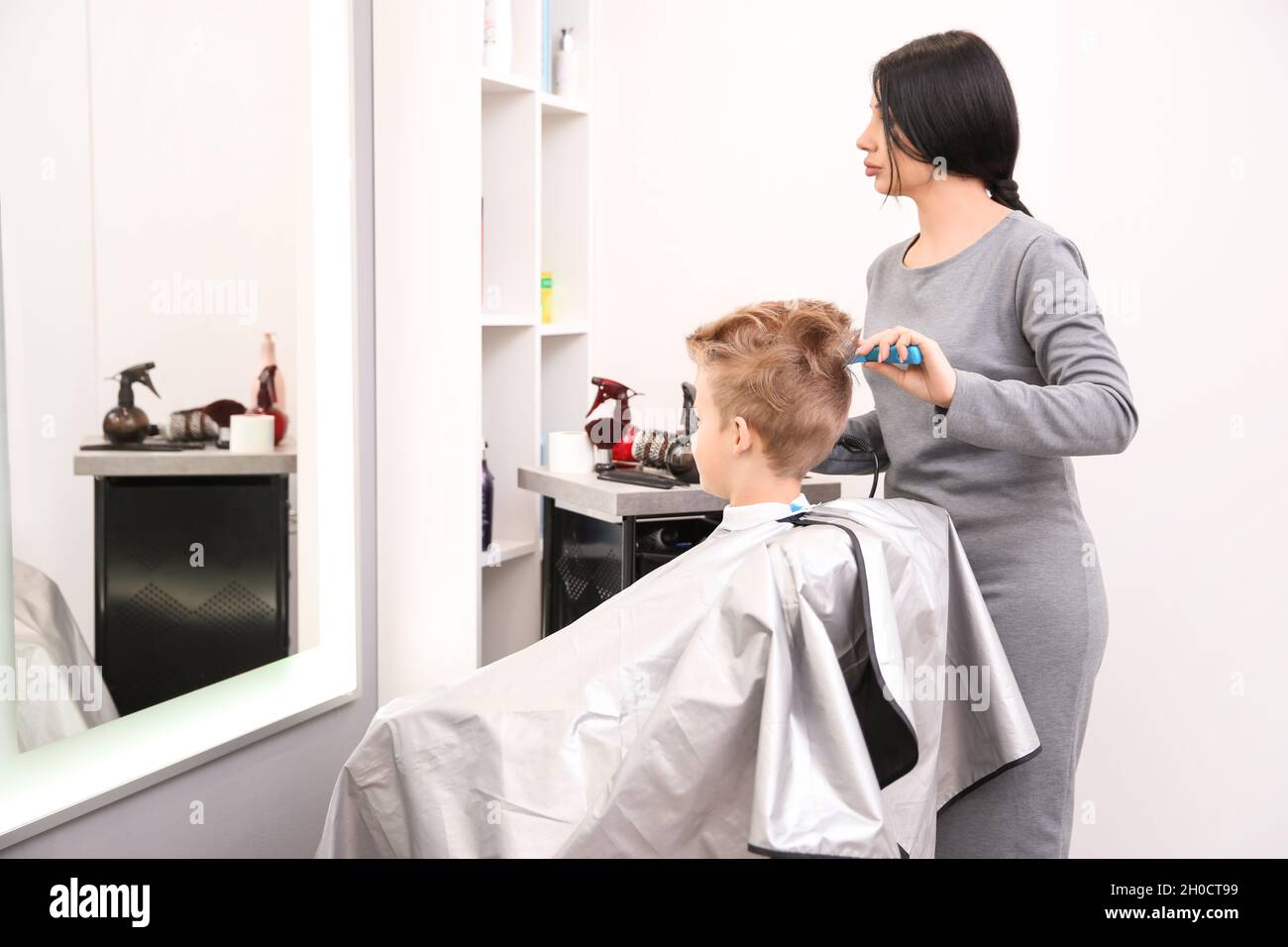 Professional female hairdresser working with little boy in salon Stock ...