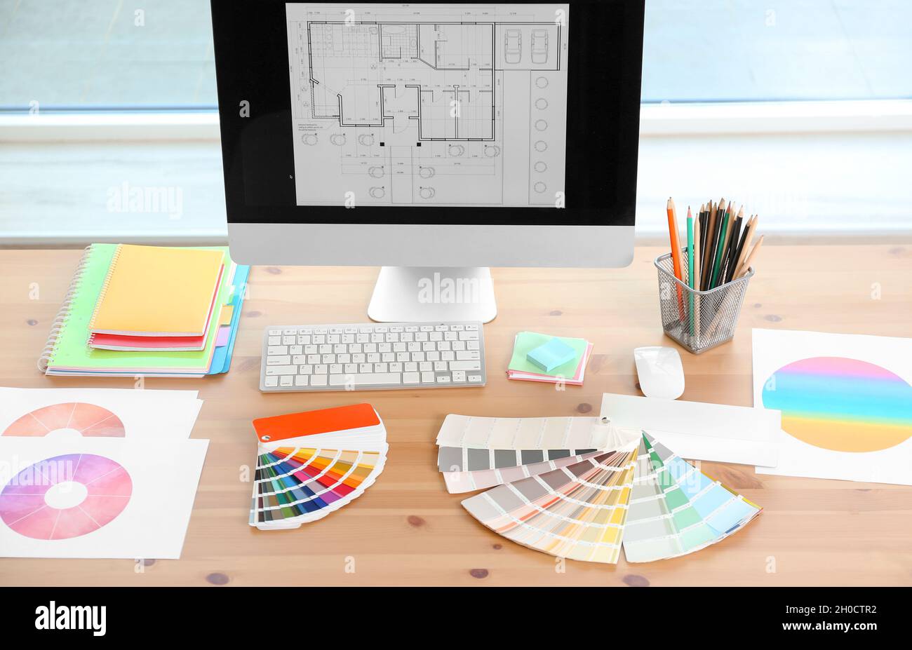 Designer's workplace with computer and paint color palette samples on ...