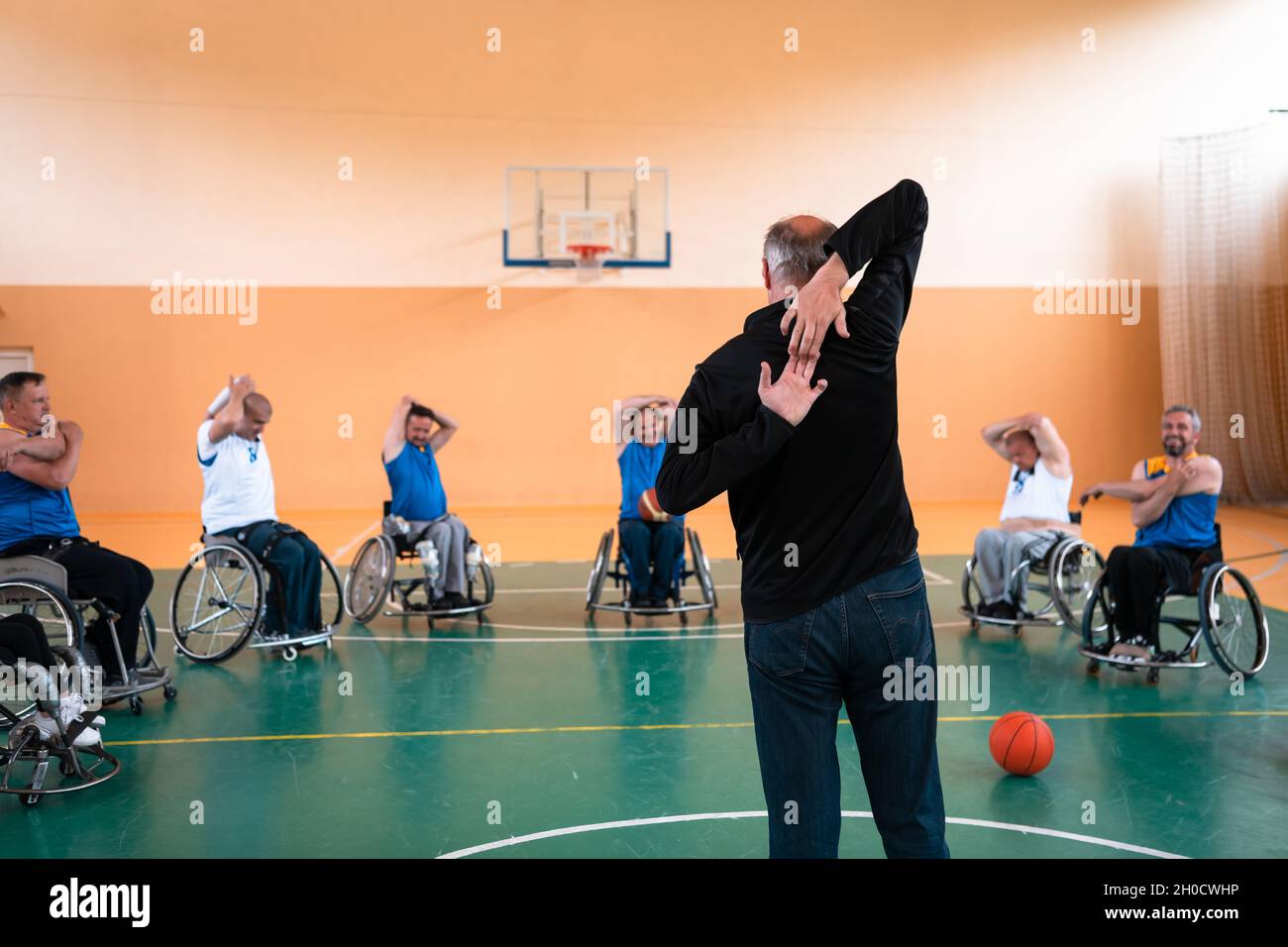 the selector of the basketball team with a disability stands in front ...