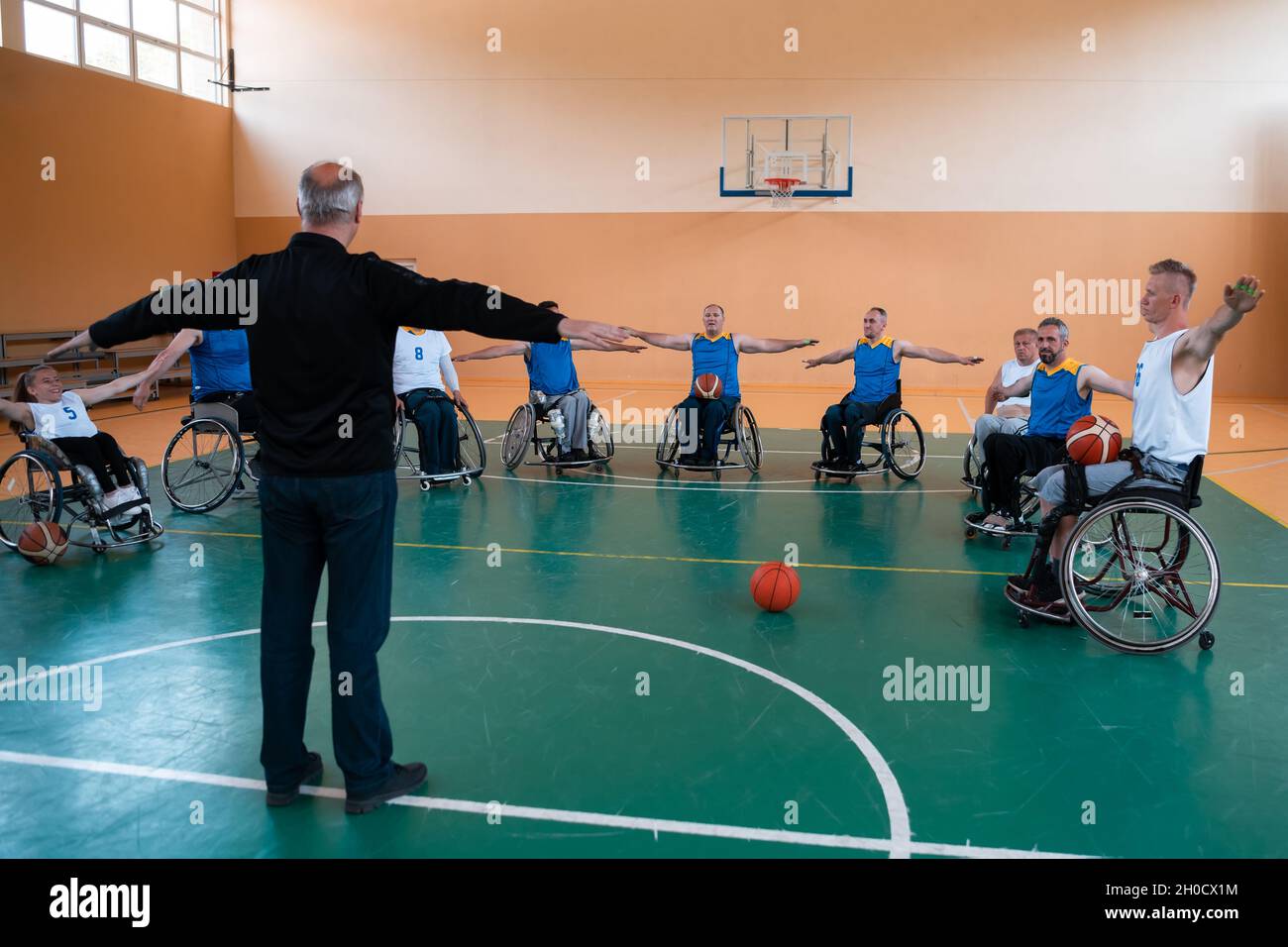the selector of the basketball team with a disability stands in front ...