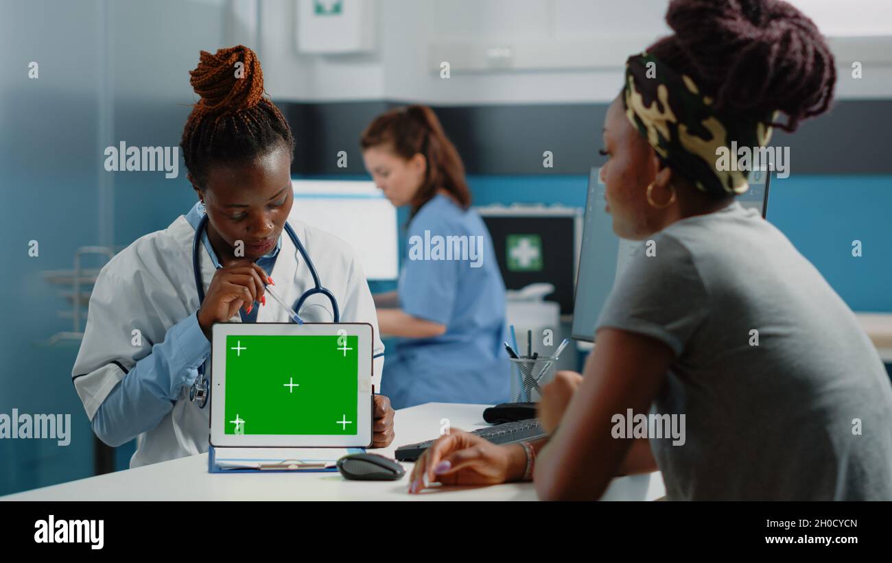 Doctor and patient looking at green screen on tablet for annual checkup ...
