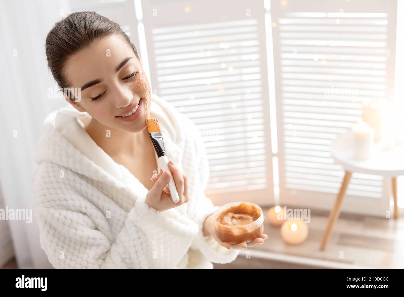 Young woman applying natural scrub on face in bathroom Stock Photo - Alamy