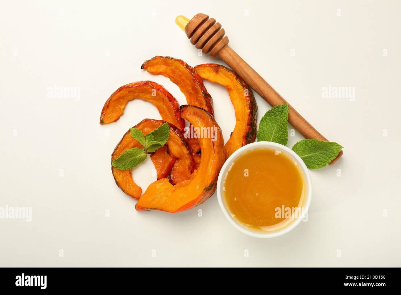 Baked pumpkin, mint, honey and dipper on white background Stock Photo ...