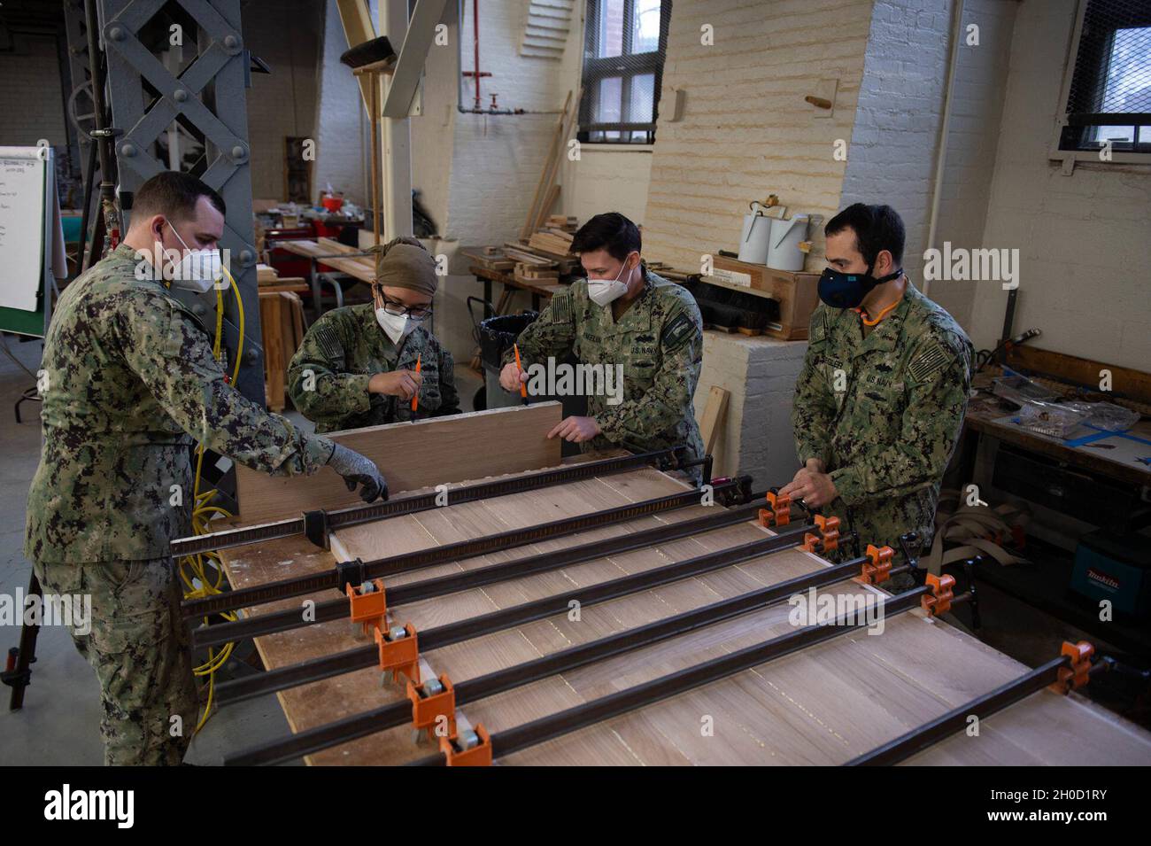 Seabees glue together wood from the USS Constitution to construct an ...