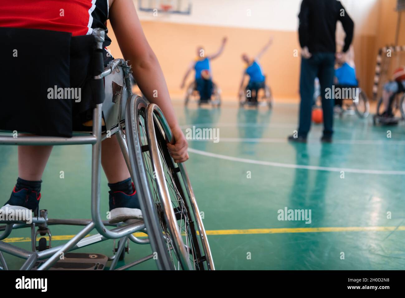 the selector of the basketball team with a disability stands in front ...