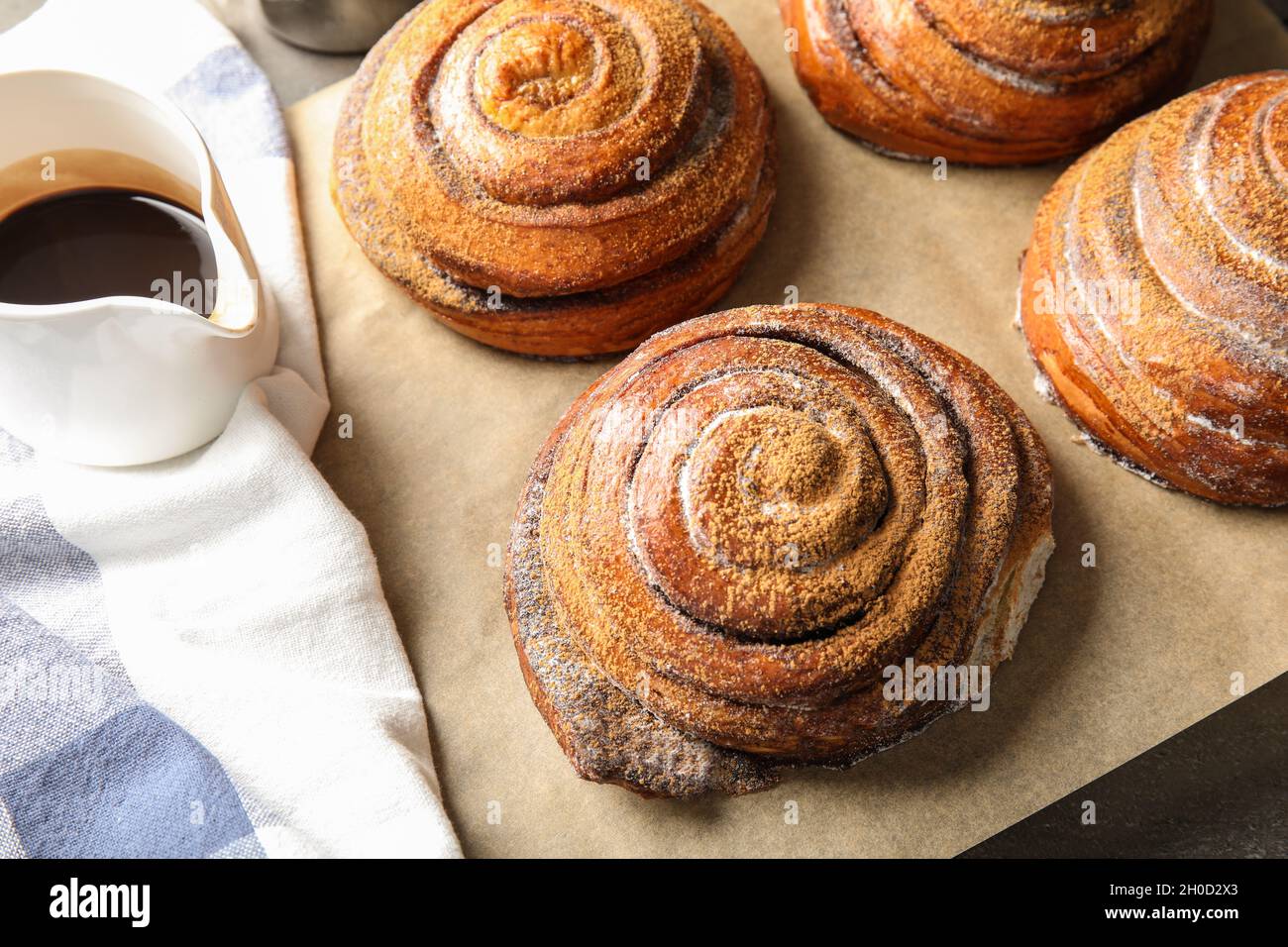 Cinnamon rolls and jug with chocolate syrup on table Stock Photo - Alamy