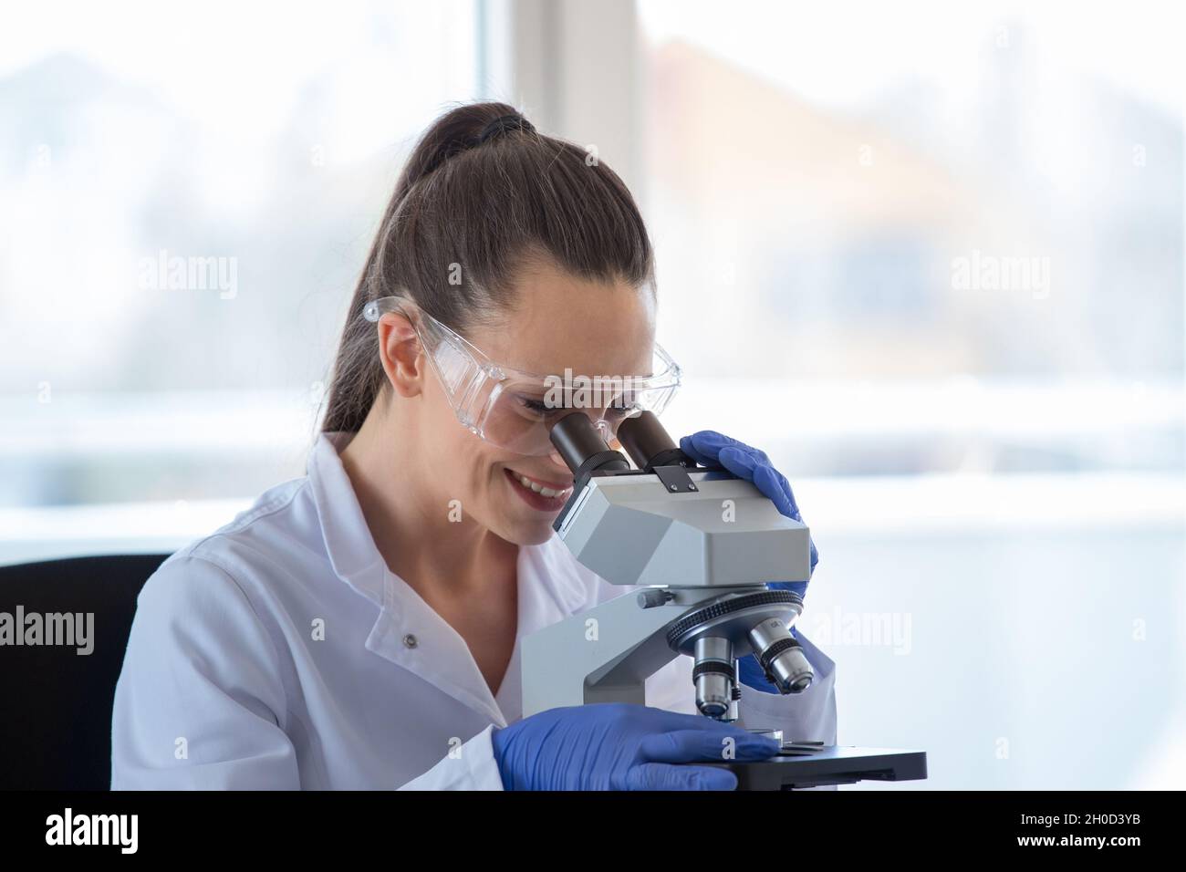 Young doctor looking through microscope hi-res stock photography and ...