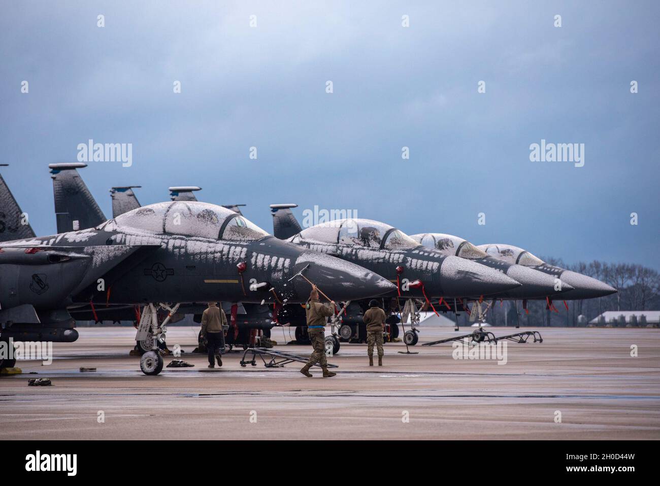 Airmen clean the snow off of an F-15E Strike Eagle at Seymour Johnson ...