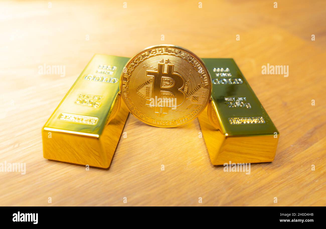 Bitcoin laying on stacked gold bars (gold ingots) rendered with shallow ...