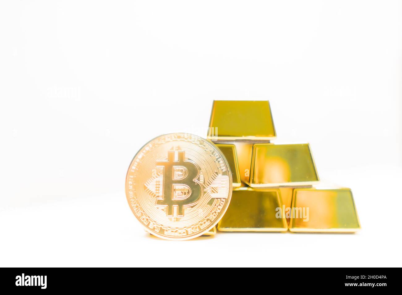 Bitcoin laying on stacked gold bars (gold ingots) rendered with shallow ...