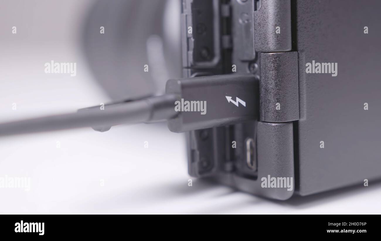 Close-up of wired charging of black electronic device. Action. Charging ...