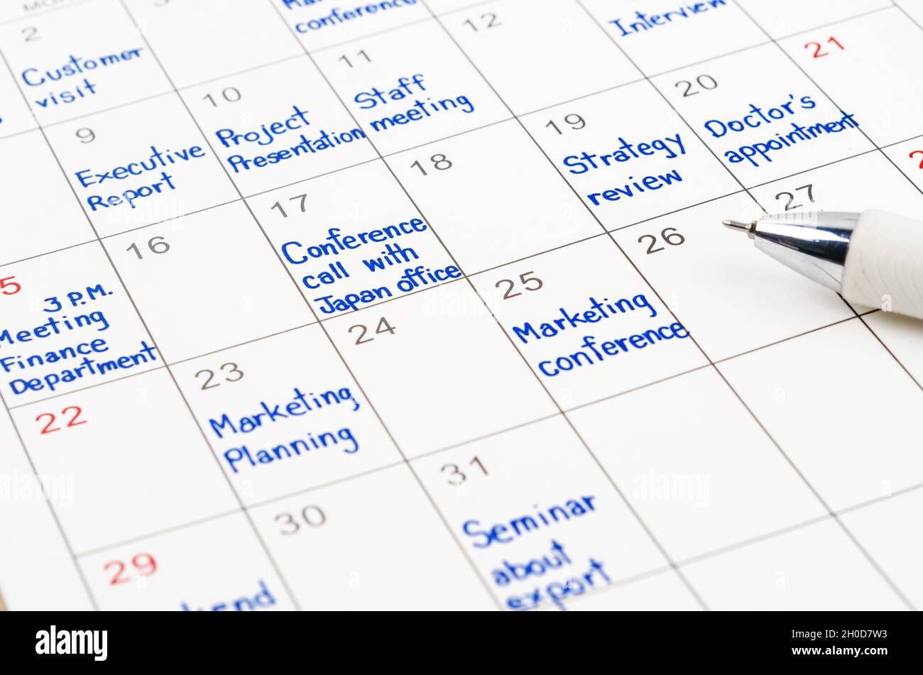 Handwriting scheduling appointments on calendar sheet with pen Stock ...