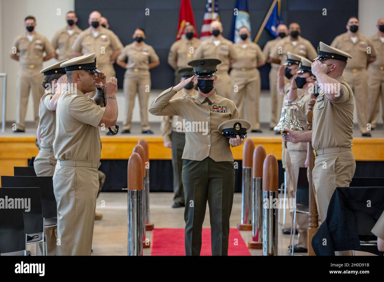 A newly pinned chief petty officer (CPO) salutes during the CPO pinning ...