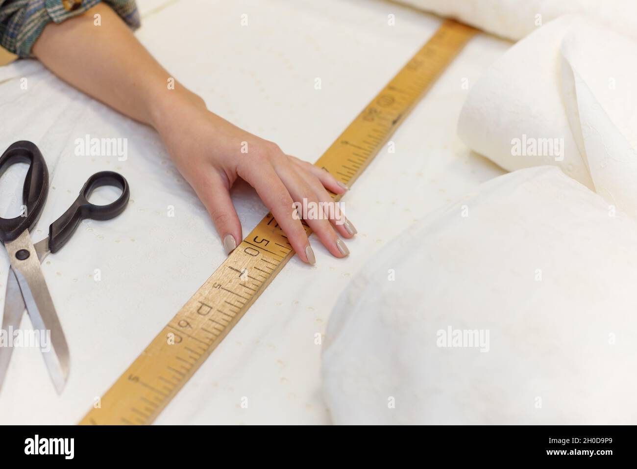 Scissors and a sewing ruler are on cotton fabric. Textile sale and ...