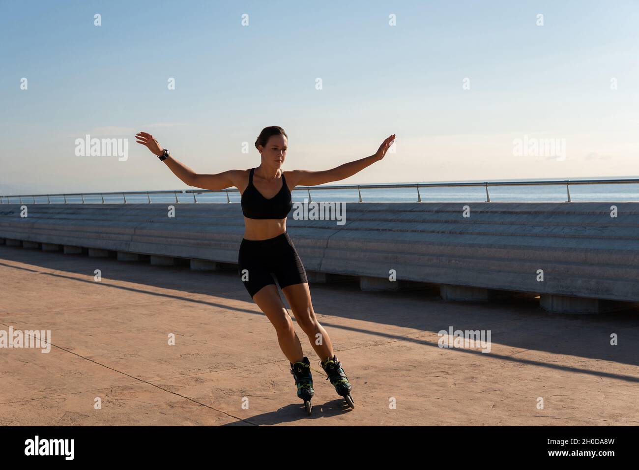 Full body female athlete with outstretched arms doing trick while ...