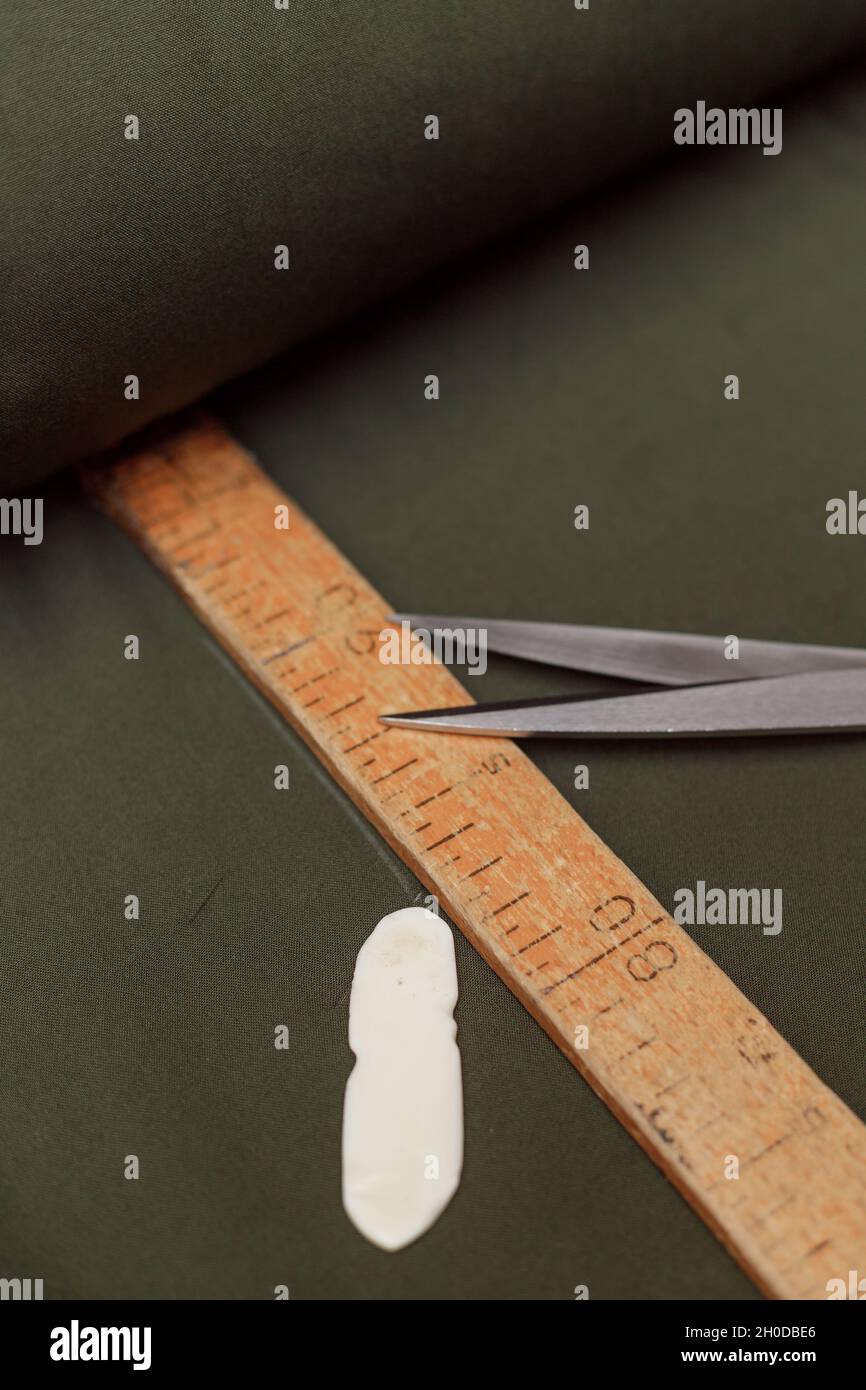 tailor marks up textile using soap and wooden ruler on pattern cutting ...
