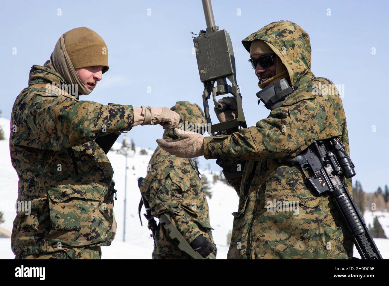 U.S. Marine Corps Cpl. Dylan Donner (left) hands Cpl. Jquan Milligan ...