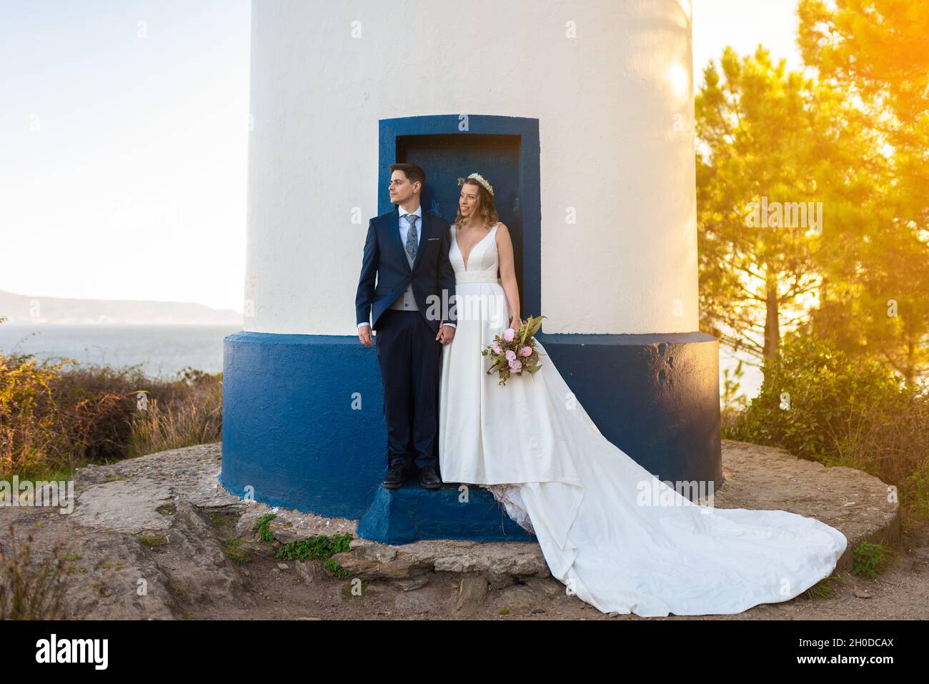 Just married couple on the door of a lighthouse at sunset Stock Photo ...