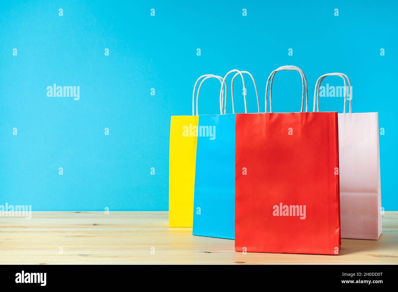 Multi-colored paper bags for good shopping on the table and colored ...