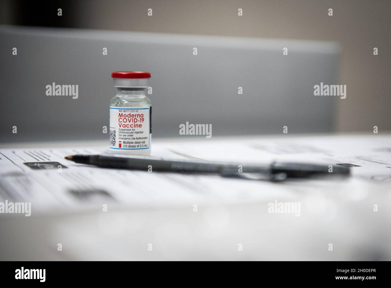 A vial of the Moderna COVID-19 vaccine sits on vaccination paperwork at ...