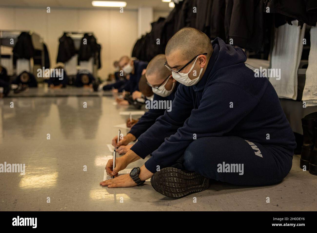 Recruits fill out ID application forms according to instructions from a ...