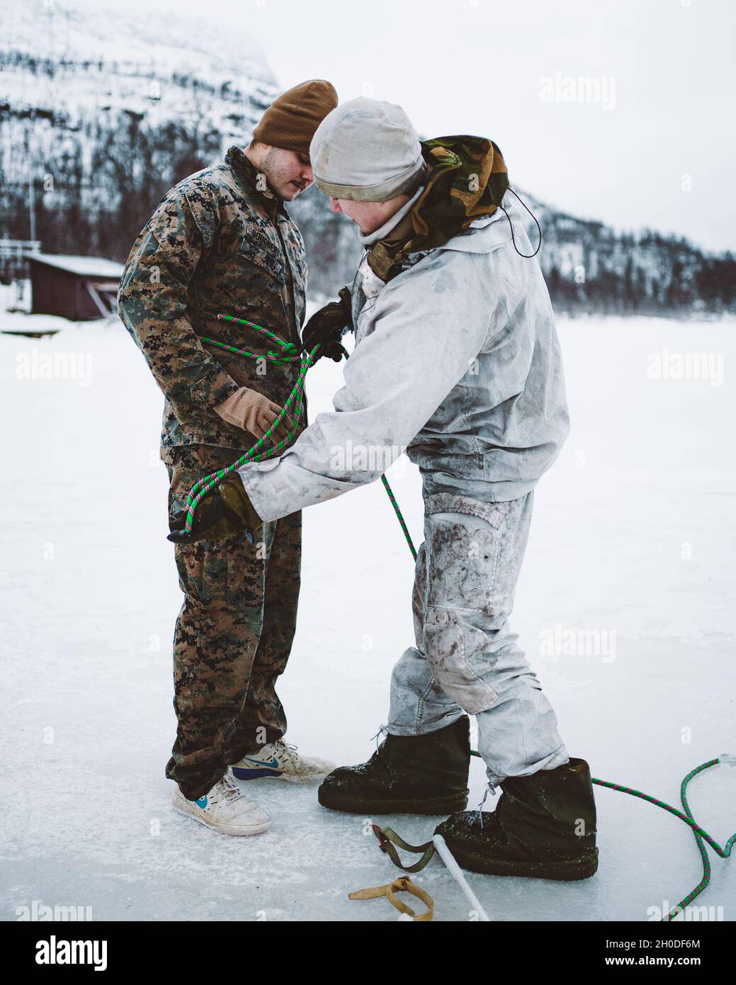 A Norwegian Army soldier ties a safety harness around a U.S. Marine ...