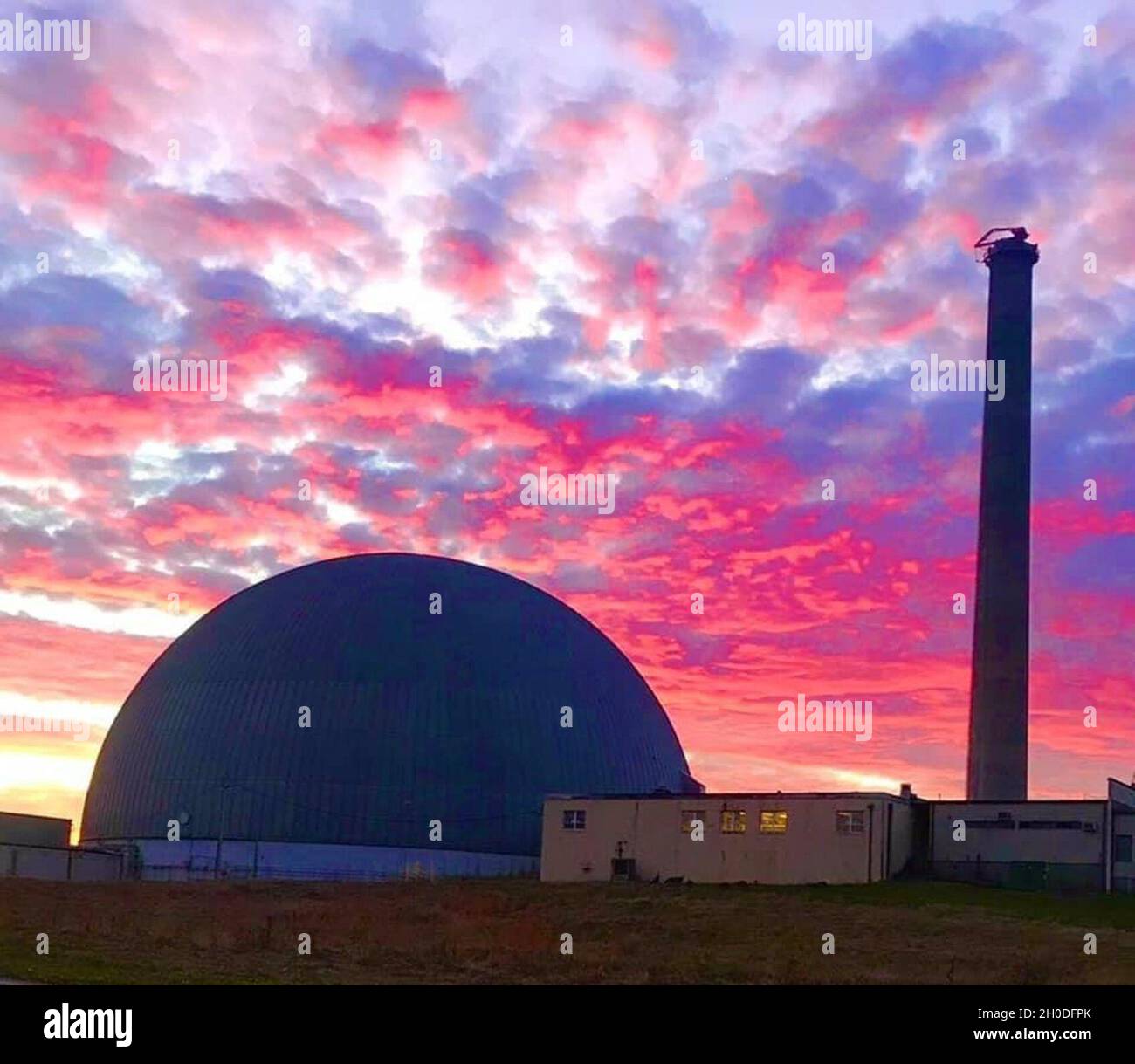 The stack standing next to a domed building that is part of the ...