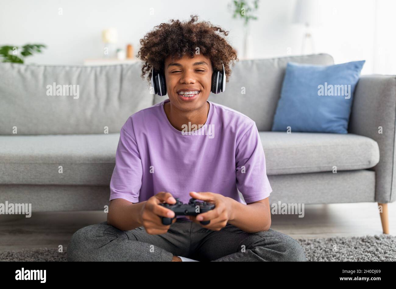 Portrait of cool black teen gamer with controller playing online video ...