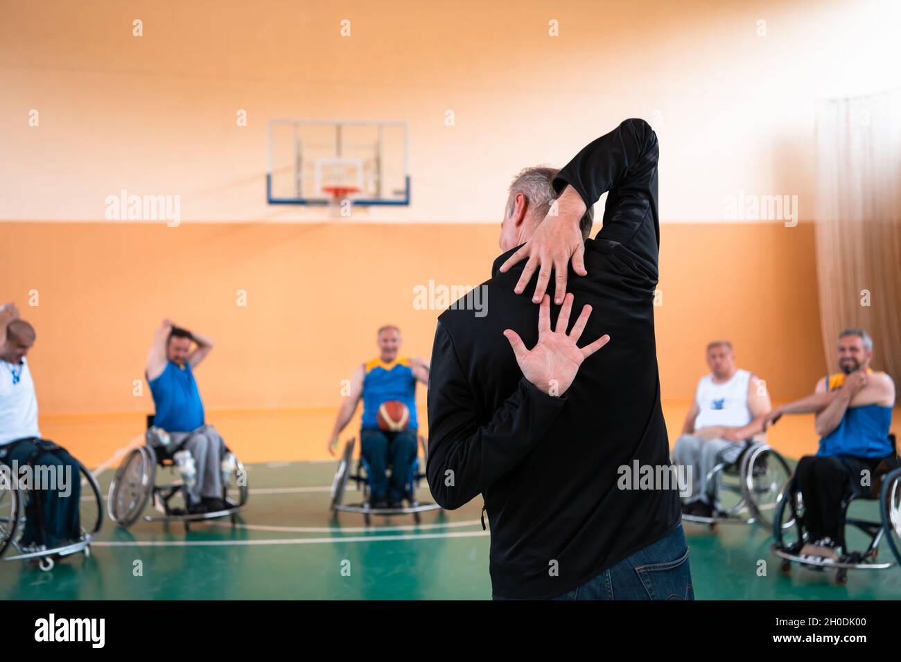 the selector of the basketball team with a disability stands in front ...