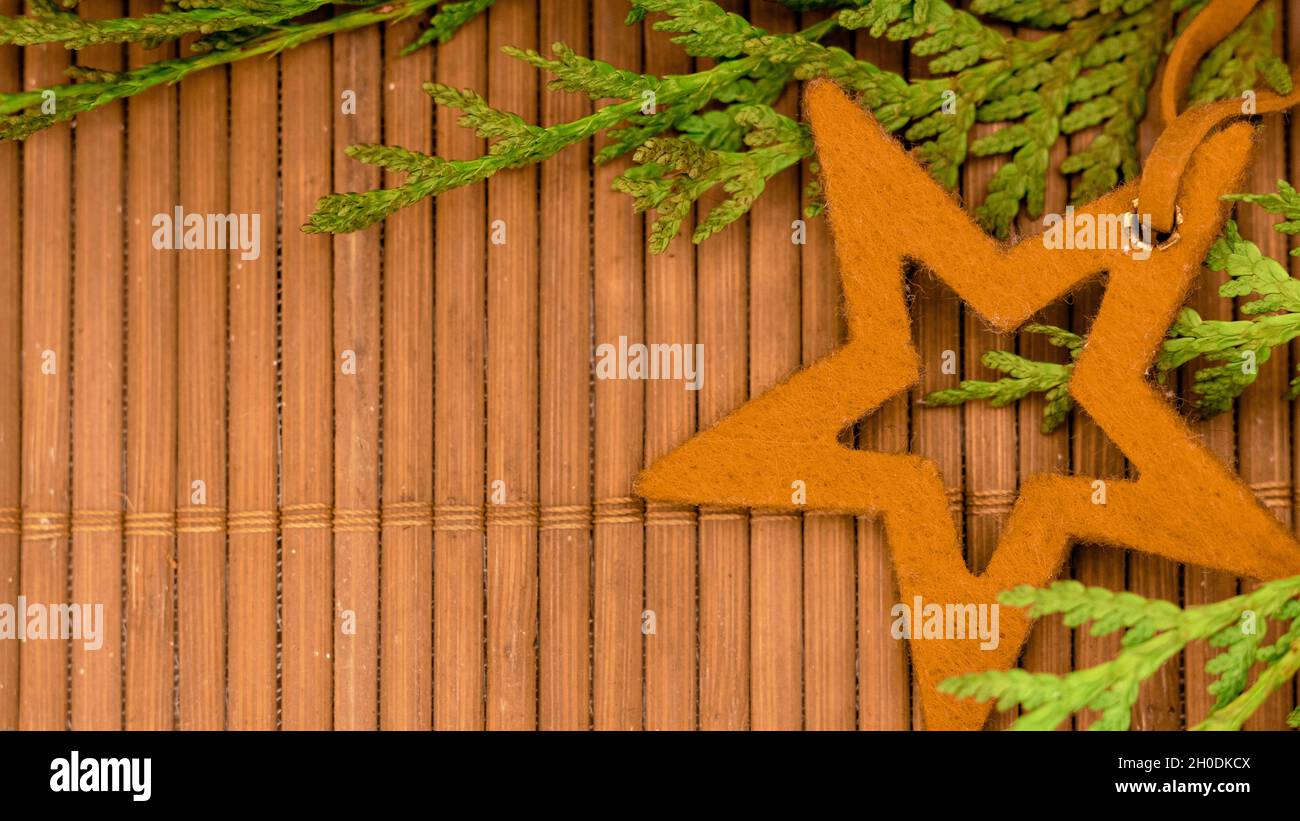 Red christmas star and tree branch on wooden background. Top view. Copy ...